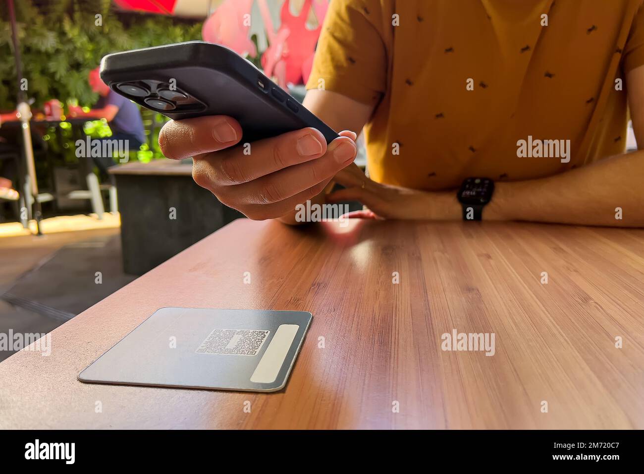 Man scanning qr code from the table in the cafe or restaurant with his ...