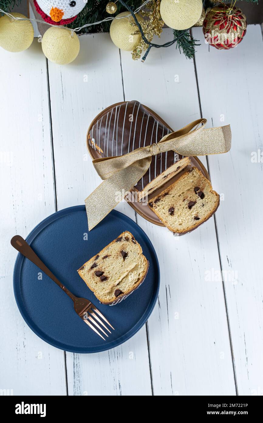 Chocotone slice on a plate, next to a fork, ribbon bow and a Christmas ...