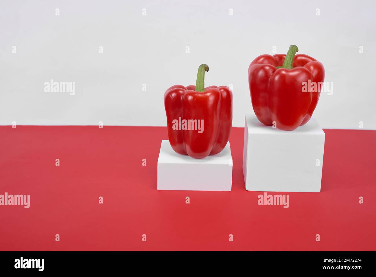 two fresh red chiles ready to cook on a red and white background, no ...