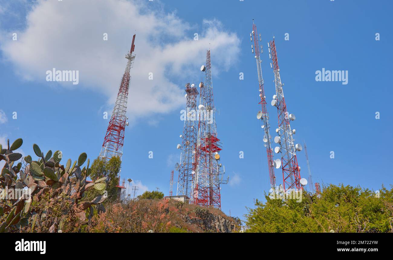 communication towers on top of a mountain in the middle of the desert forest, blue sky in summer ...