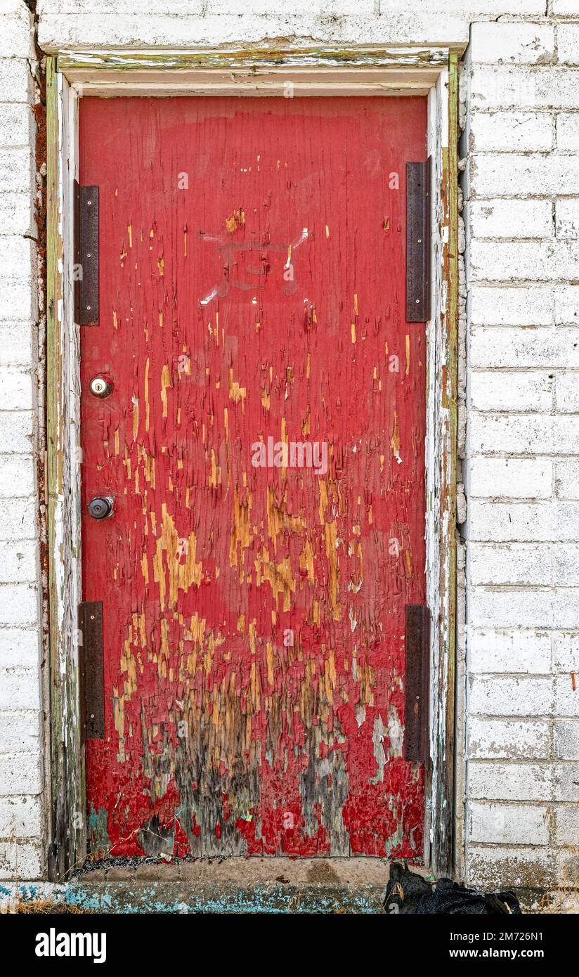 Door with peeling red paint in an abandoned white brick building Stock ...
