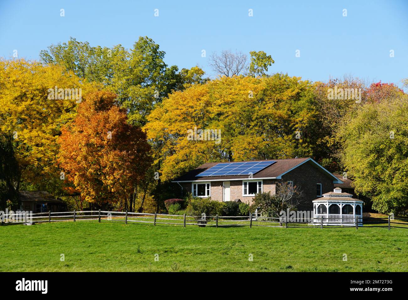 A residential home with a solar system surrounded by beautiful fall ...