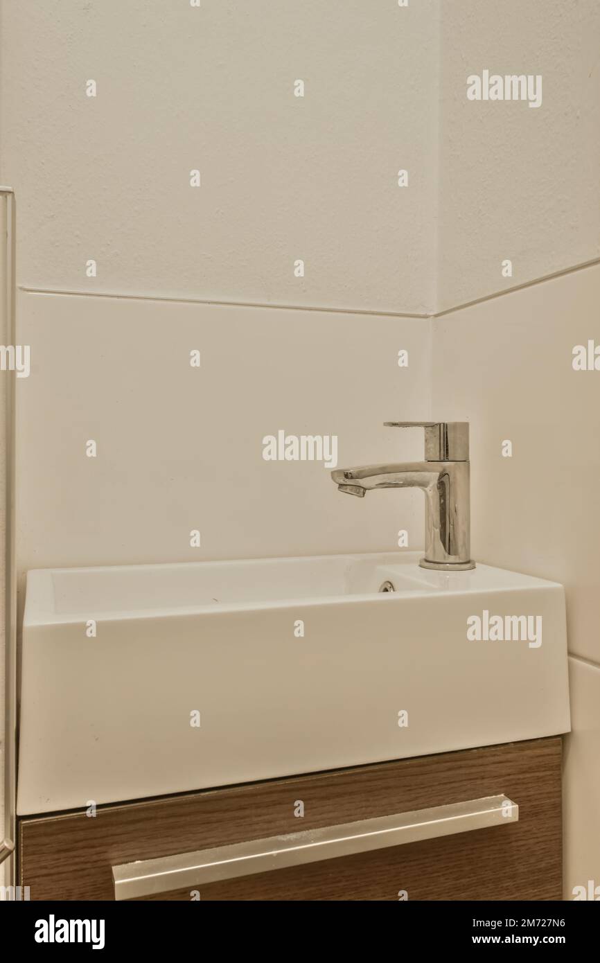 a white sink in a bathroom with wood paneling on the wall behind it is ...