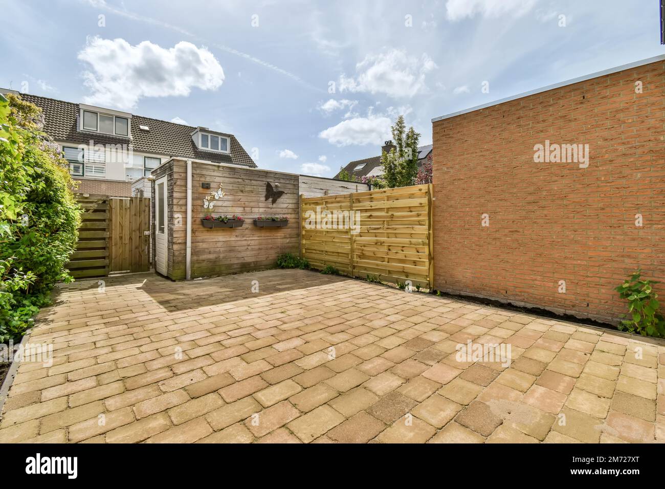 an outdoor patio with brick paversing and wooden fenced in the back ...