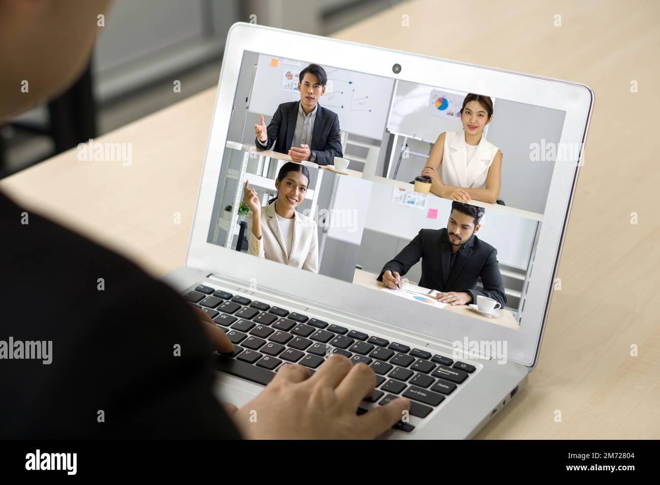 Back view of businessman sit at desk in office typing on laptop ...