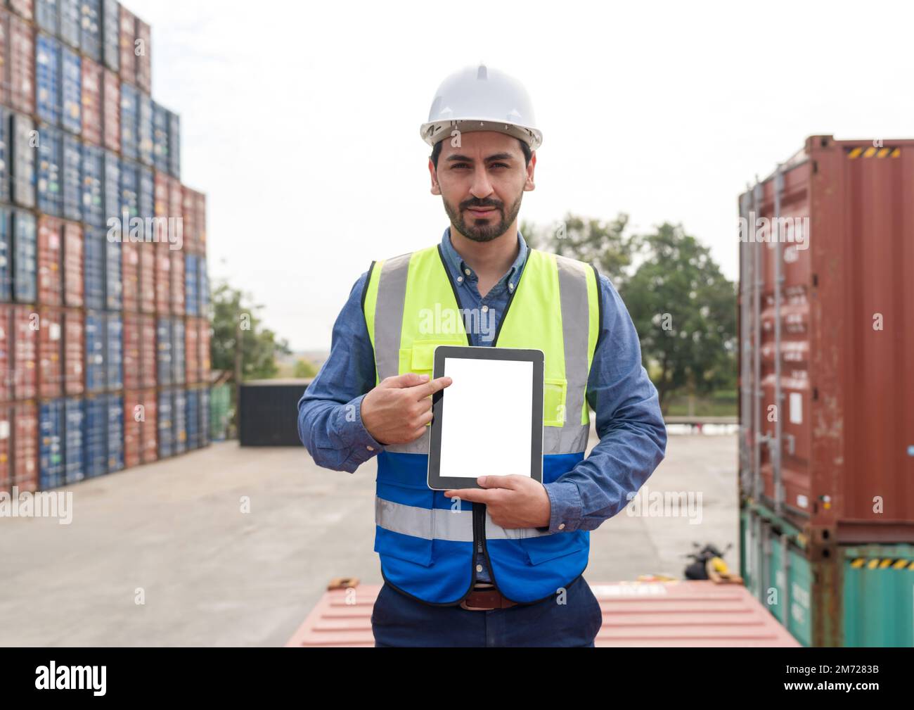 Shipment worker with safety vest and hardhat pointing finger at white ...