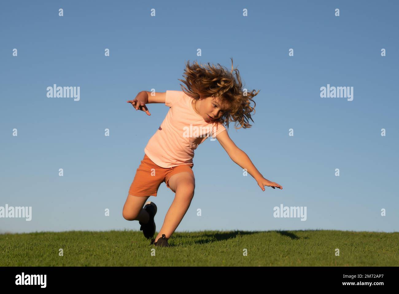 Kid falling down on the ground in summer park. Moment of the fall down ...