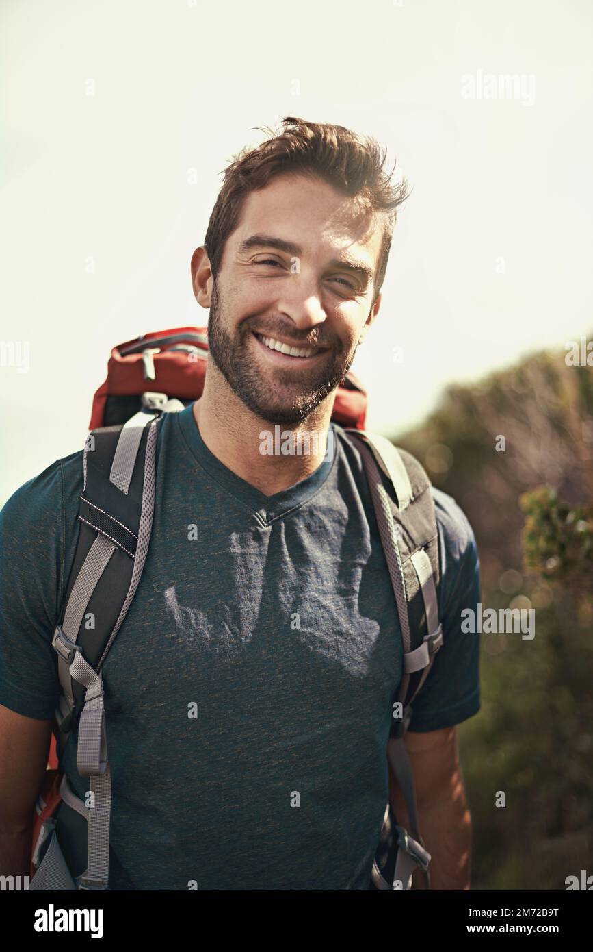 He loves hiking. Cropped portrait of a young man out hiking in nature ...