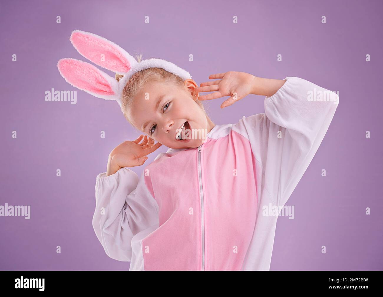 Funny bunny. Studio shot of a cute little girl dressed up in a bunny ...