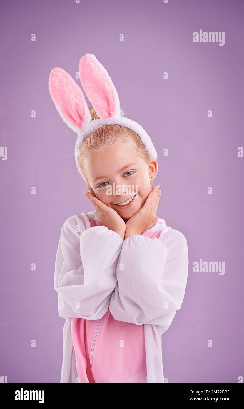 Funny bunny. Studio shot of a cute little girl dressed up in a bunny ...
