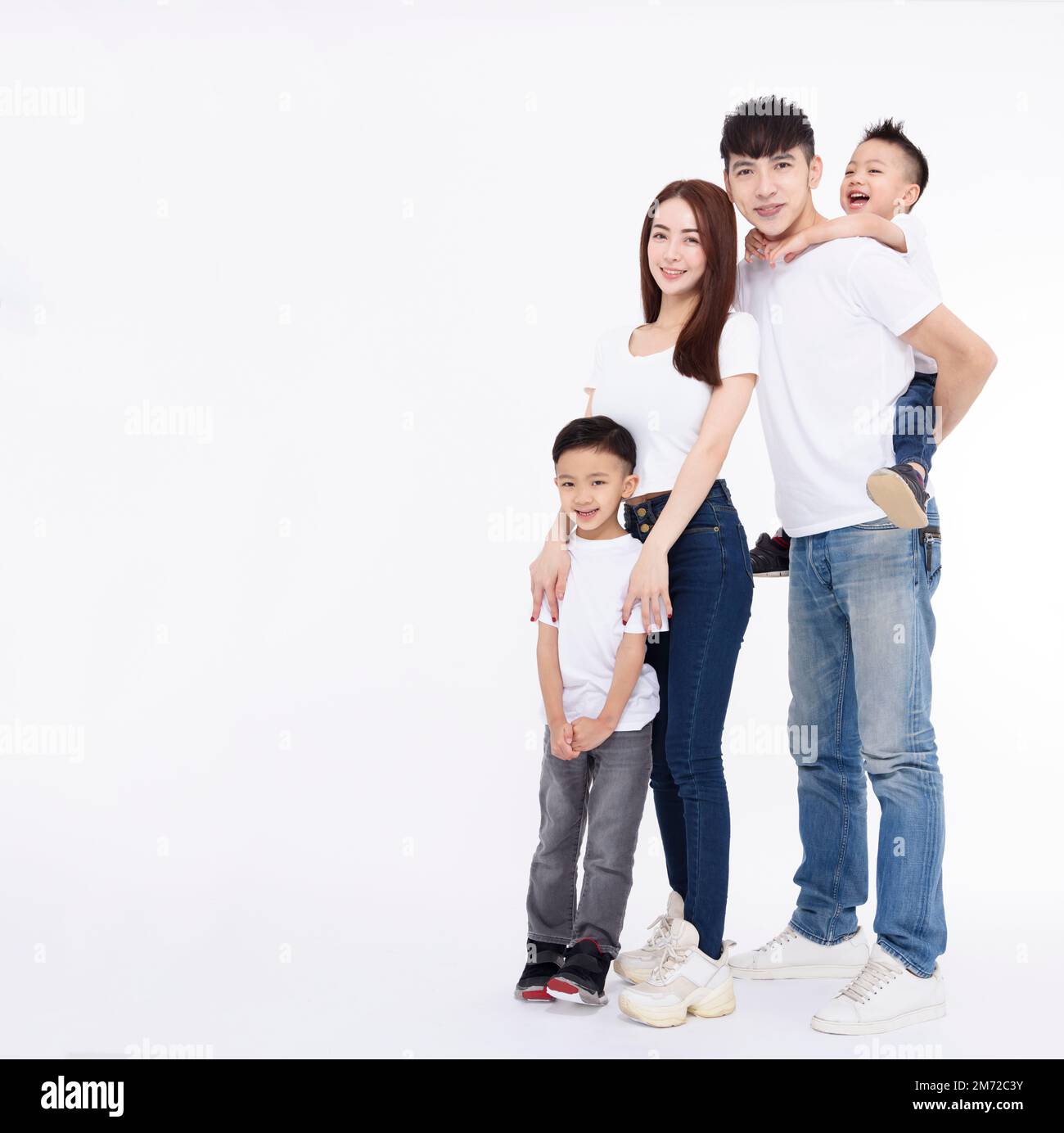 Happy Asian family standing together on white background Stock Photo ...