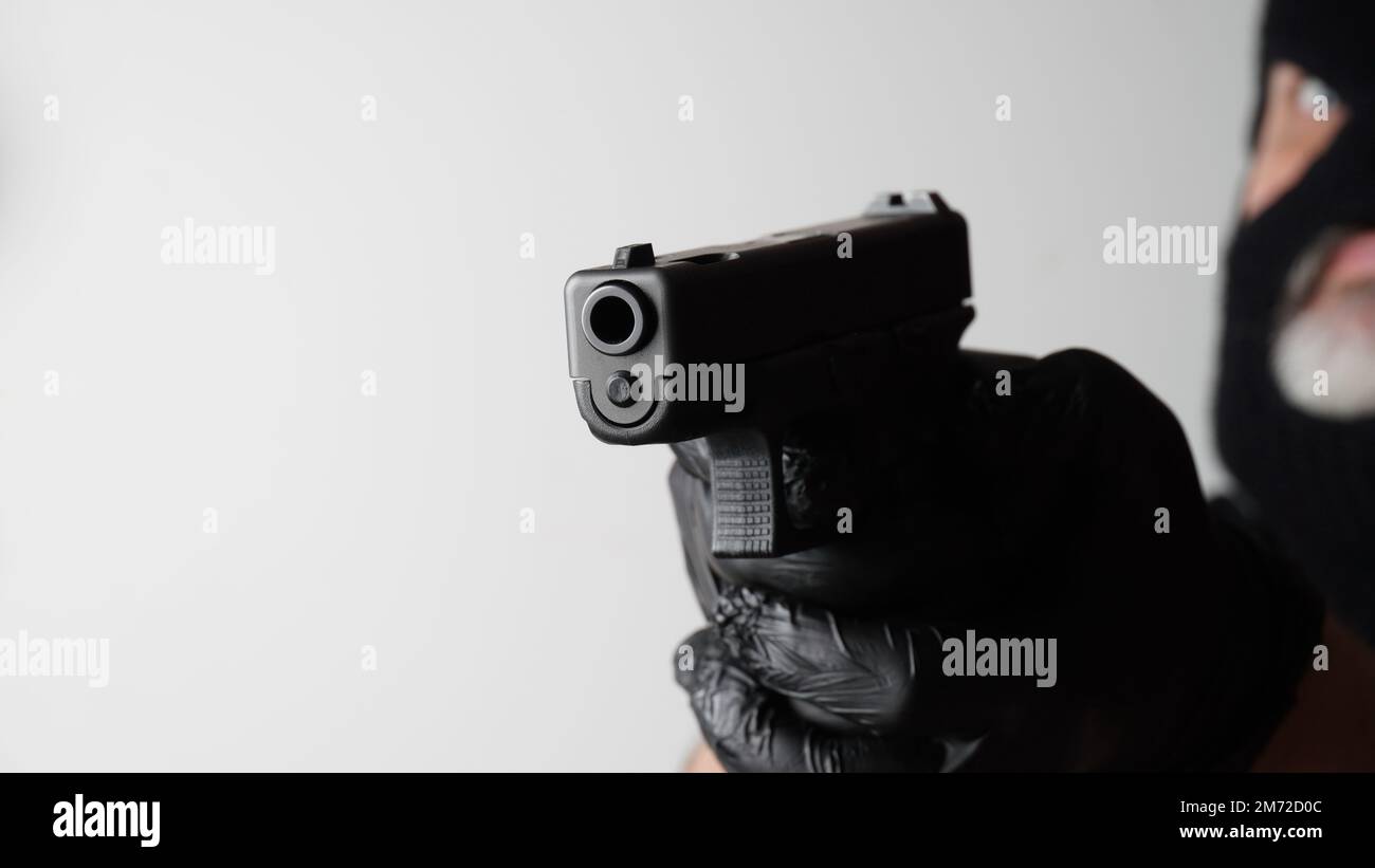 Image of male in black gloves holding pointing gun. Focus on barrel of ...