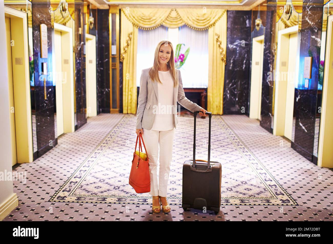 Accommodation in style. a woman walking down the corridor of a hotel ...
