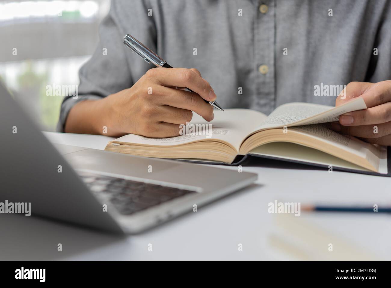 learning online class by using laptop computer and writing notebook at ...