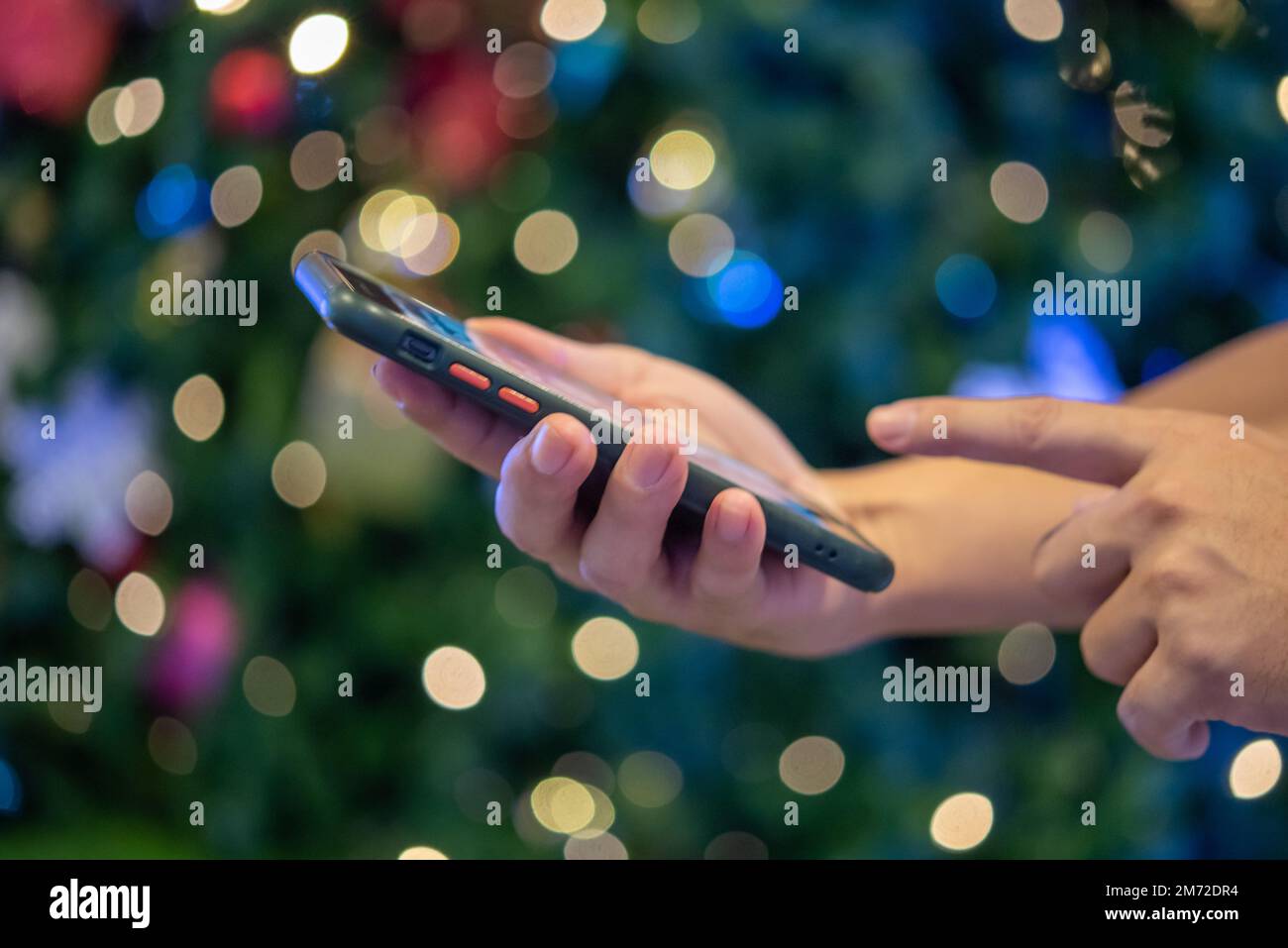 male hands using smartphone at night on city with background bokeh ...