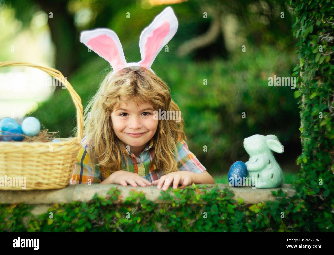 Portrait of bunny boy on Easter day. Child boy hunting eggs in garden ...