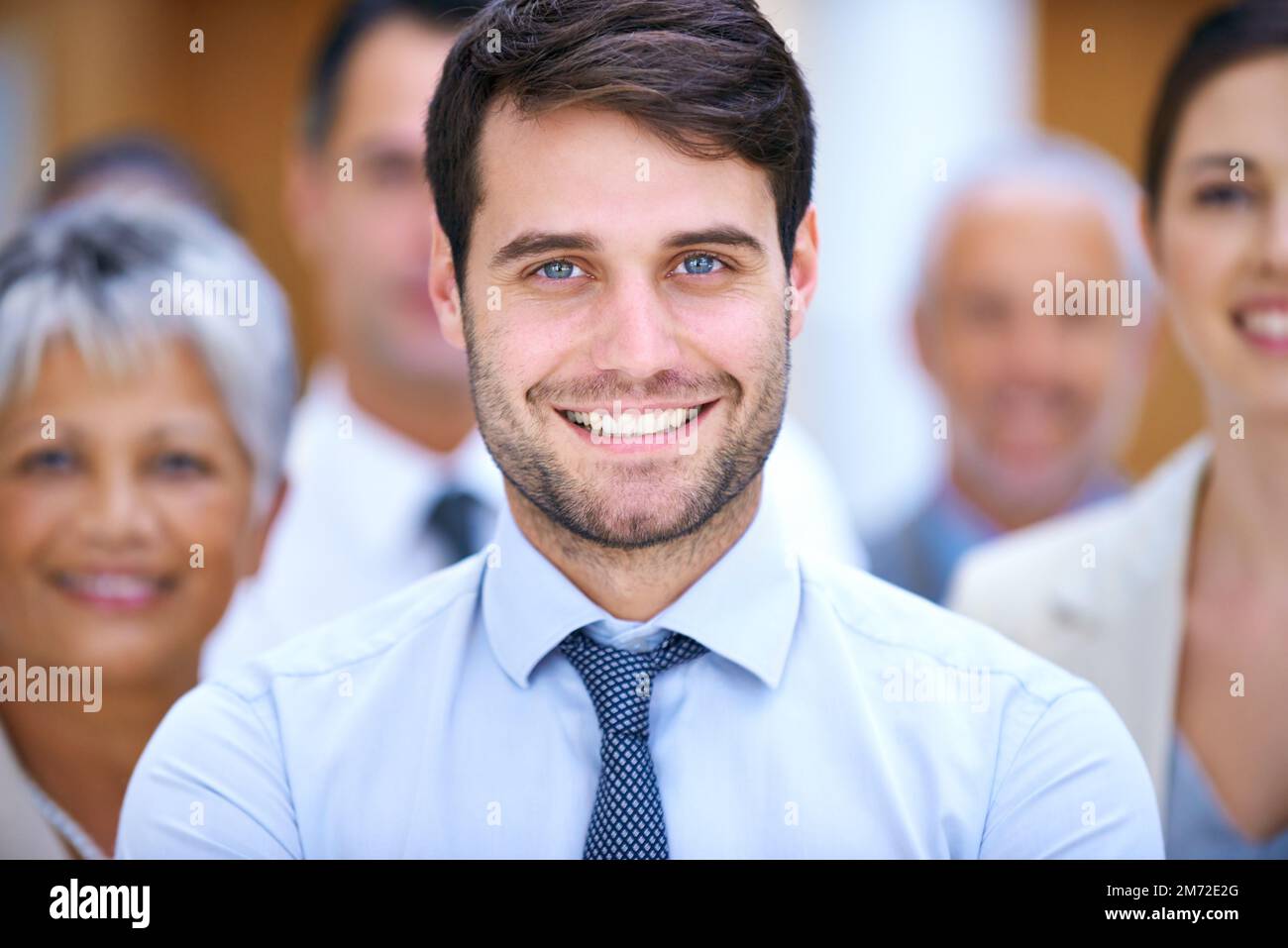 Hes the face of their company. A young man standing in front of a group ...