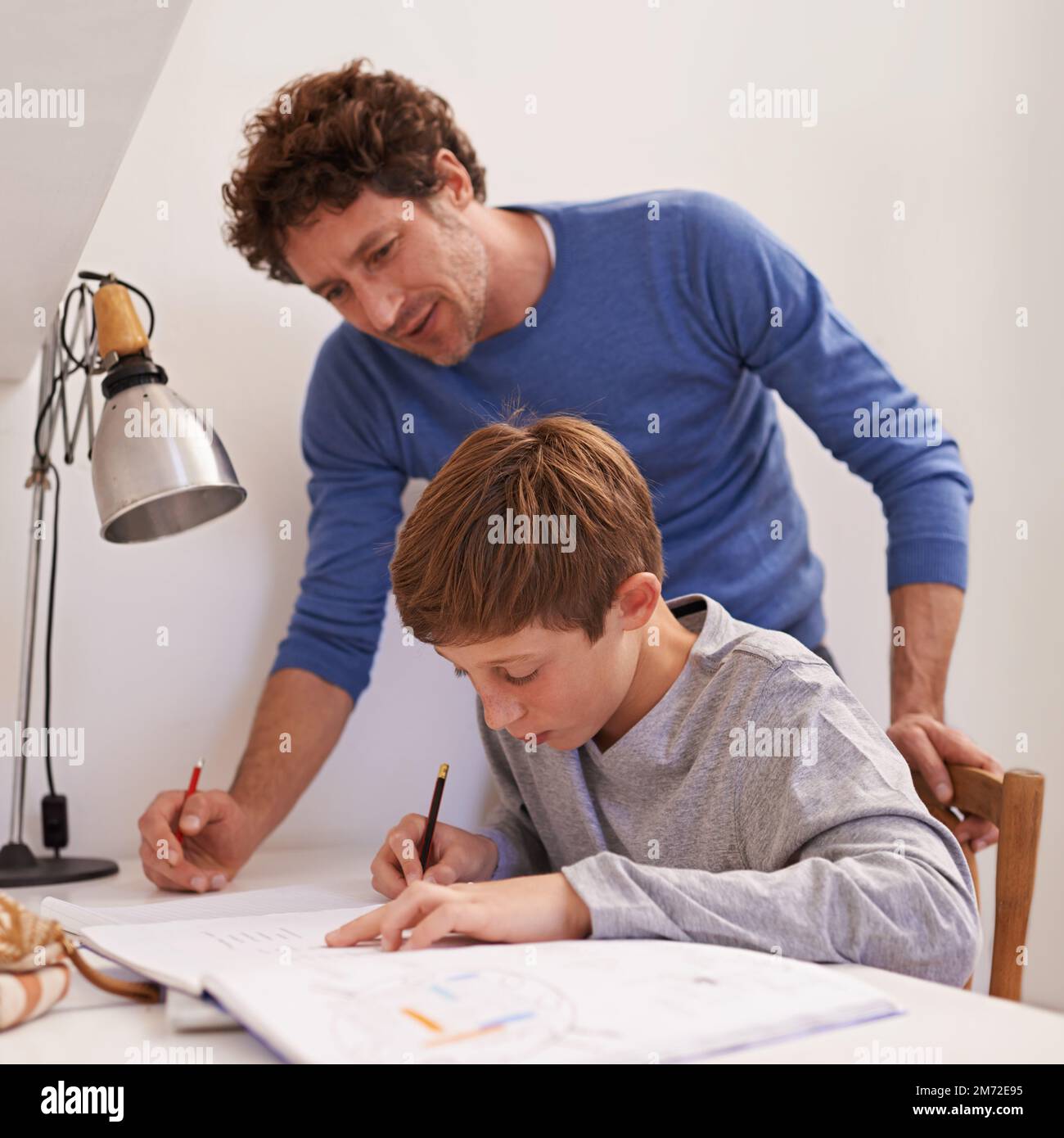 Now youve got it. a teenage boy getting some study help from his father ...