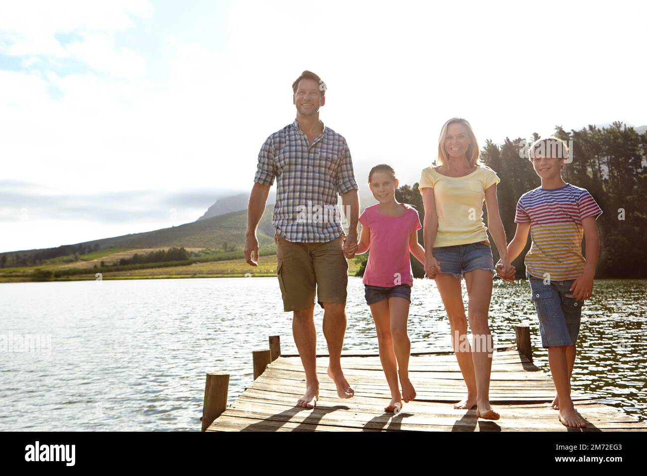 A walk on the pier. Full length shot of a family walking on a pier out ...