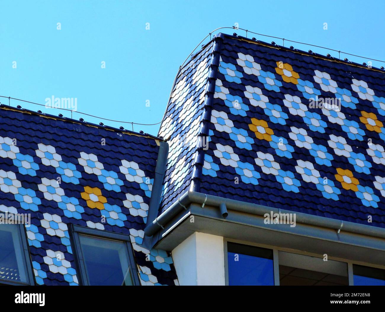 steep sloped clay ceramic tile roof with colorful blue, yellow and ...
