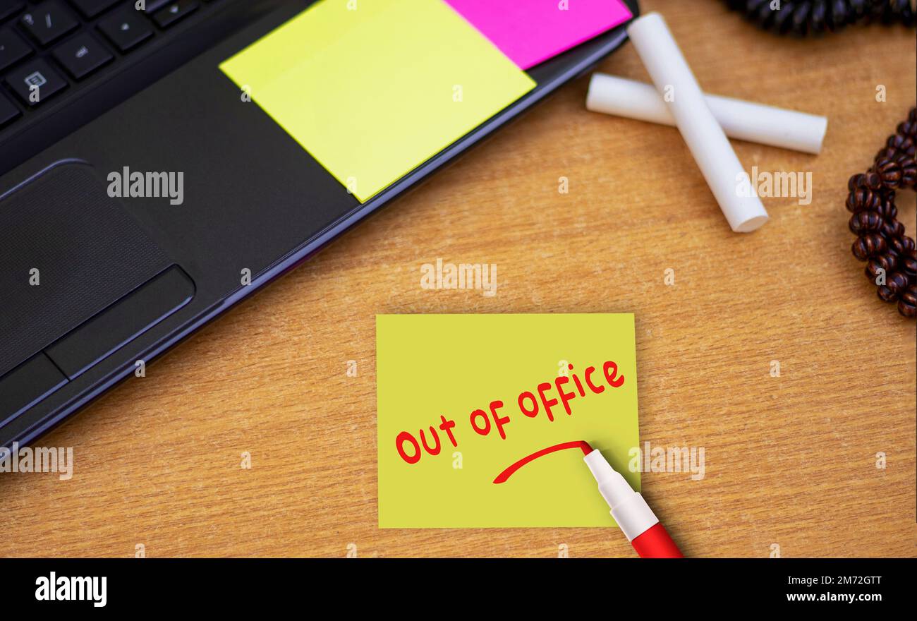 Out of office sticky note pasted on the office table at the office ...