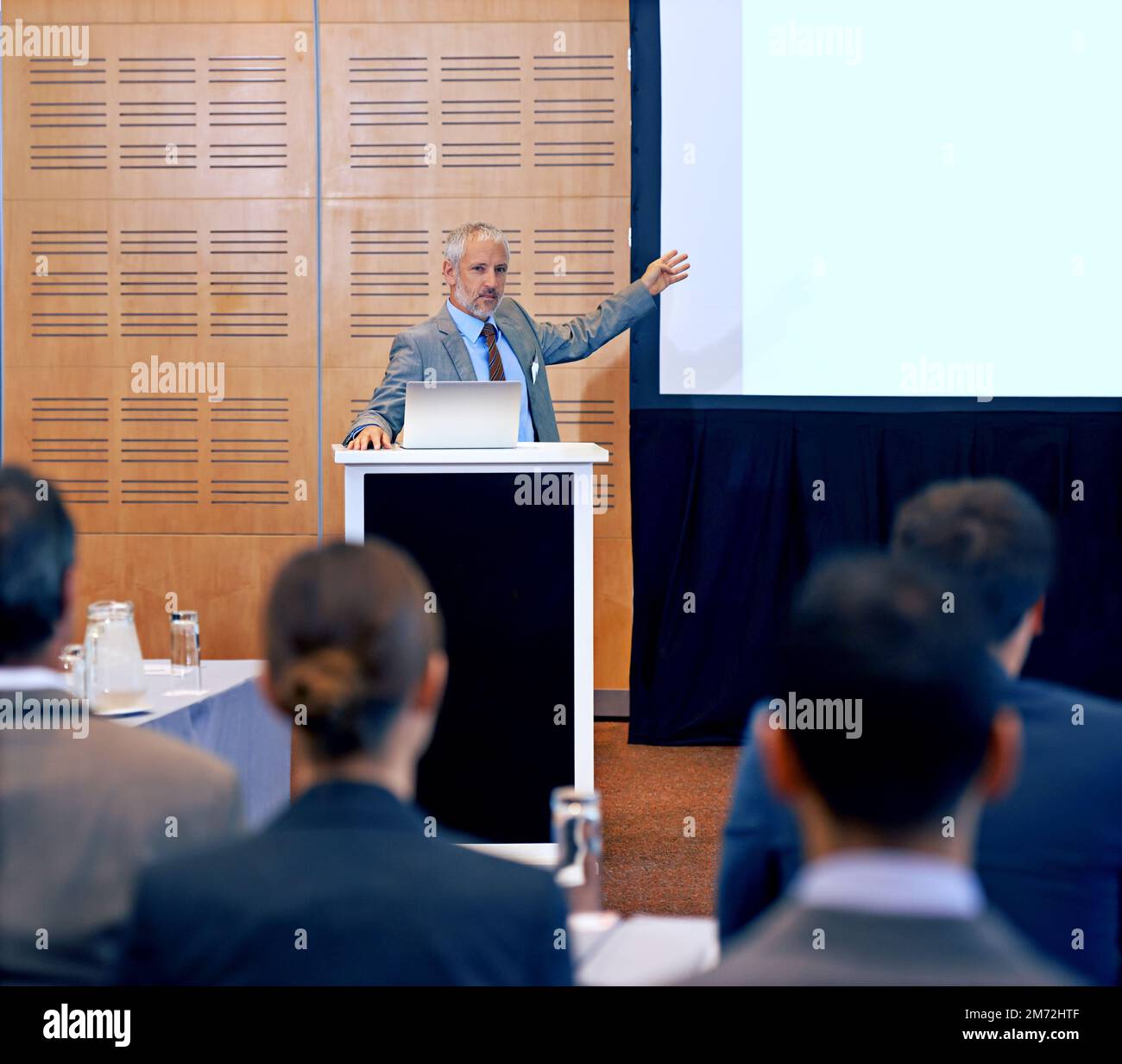 Making ideas happen. A confident businessman giving a presentation at a ...