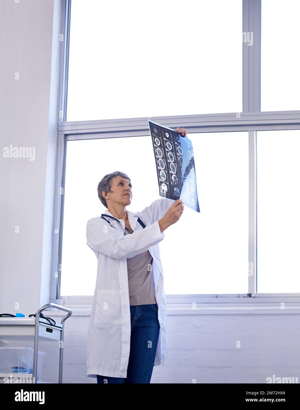 An insight into the human mind. a female doctor studying x-rays Stock ...