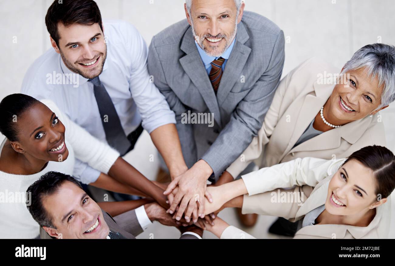 Success is in their grasp. a group of businesspeople putting their ...