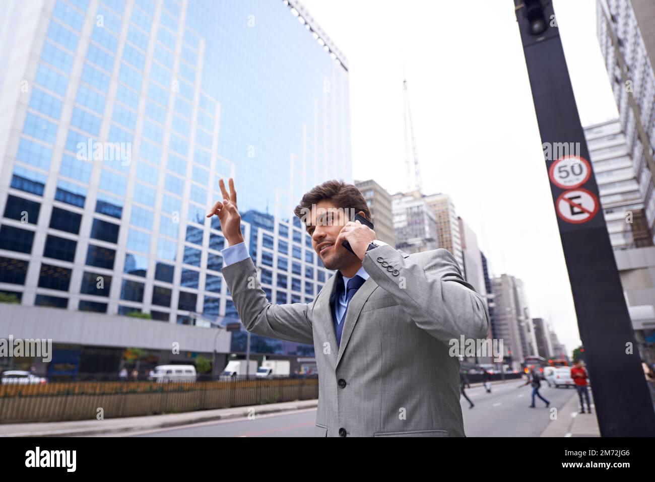 Taxi. A cropped shot of a handsome young businessman hailing a cab ...