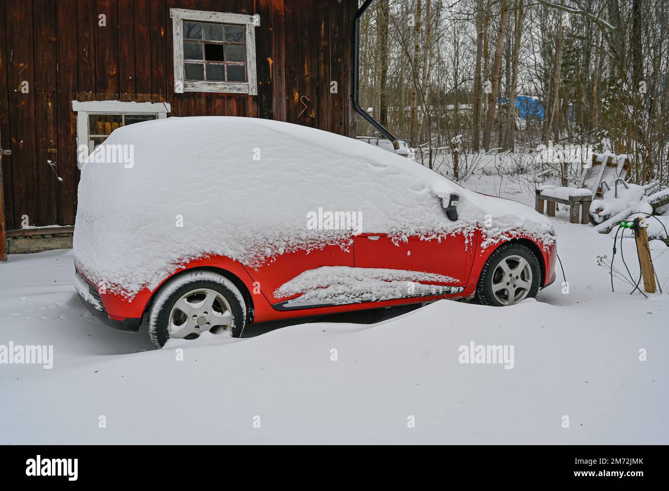 red car covered in snow Sweden january 6 2023 Stock Photo - Alamy