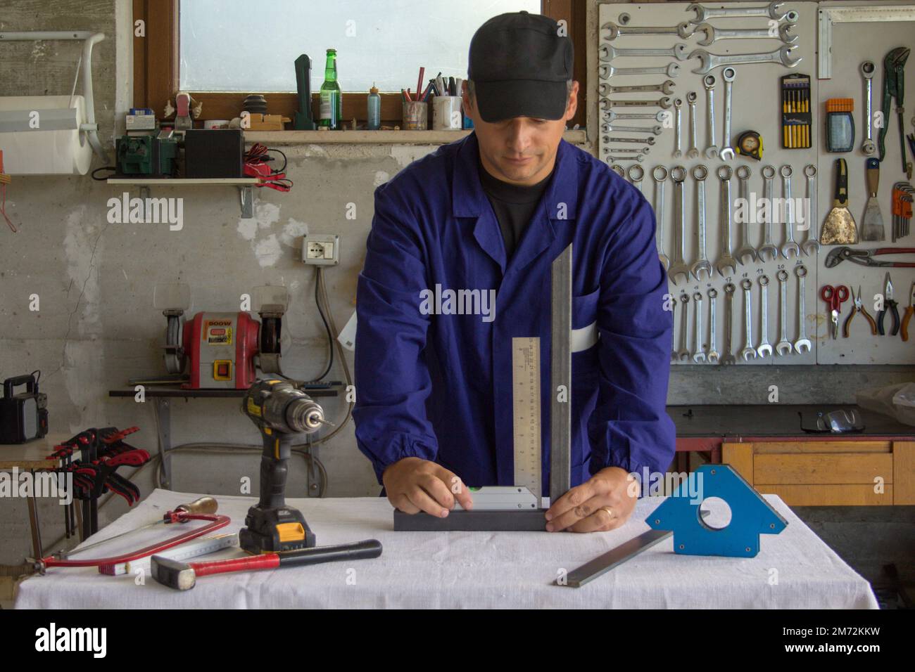 metalworker in the workshop who finds the precise angle of a mechanical ...