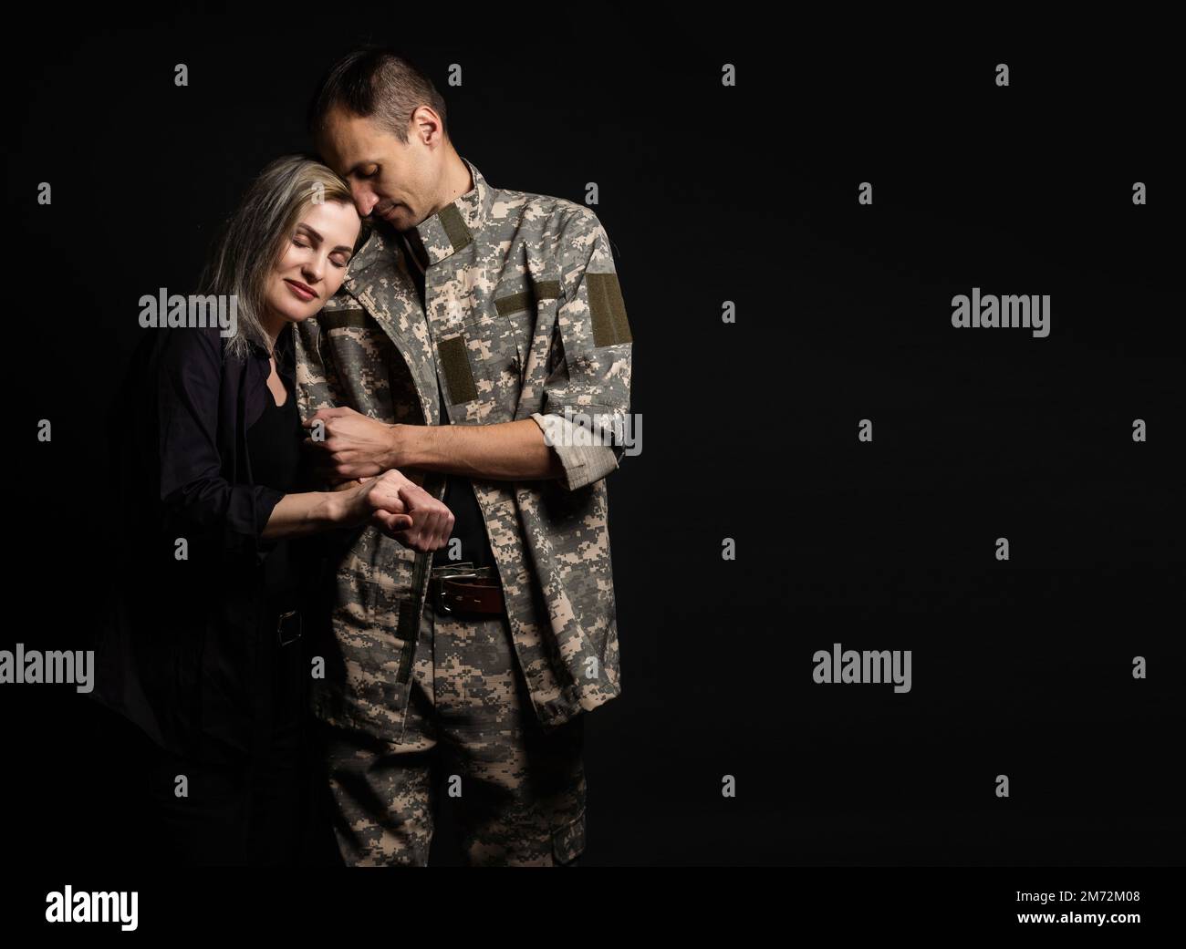 Happy woman hugging his husband came back from army. Smiling cheerful ...