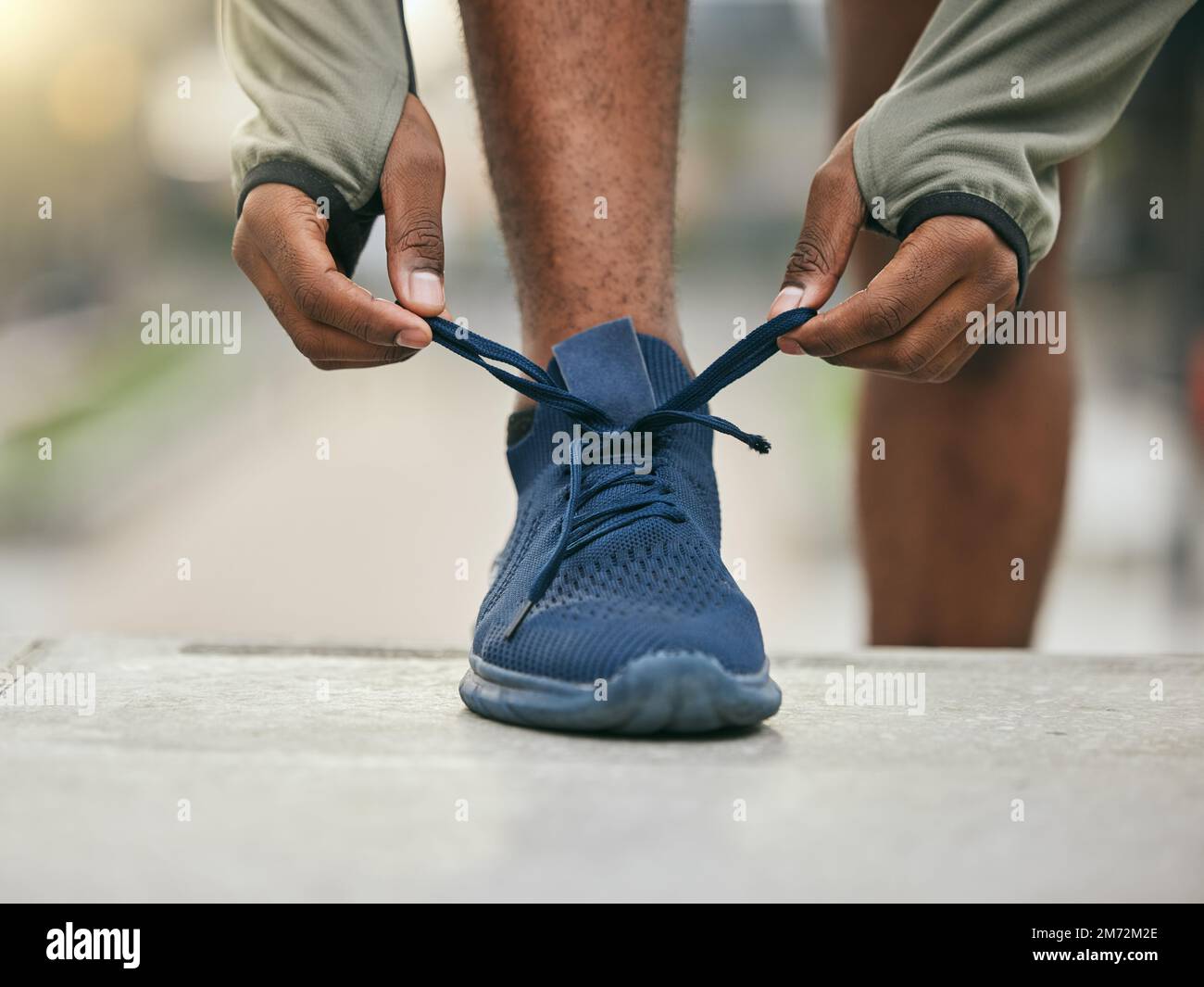 Fitness, health and black man tie running shoes before an outdoor ...