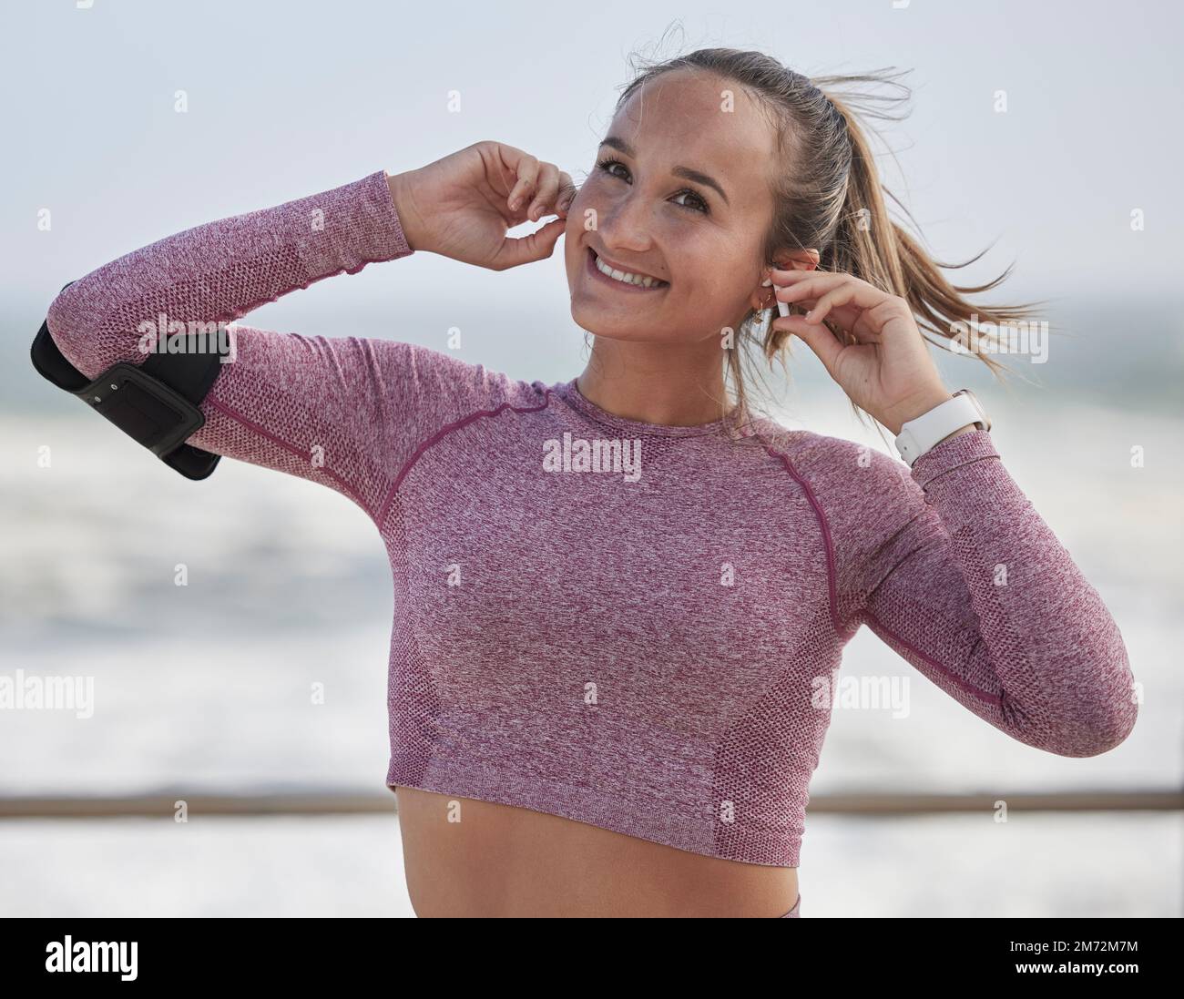 Fitness, woman with earpods for music during run at beach, exercise and ...