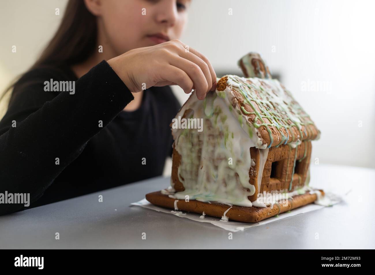 A teenage girl is eating a gingerbread house Stock Photo - Alamy