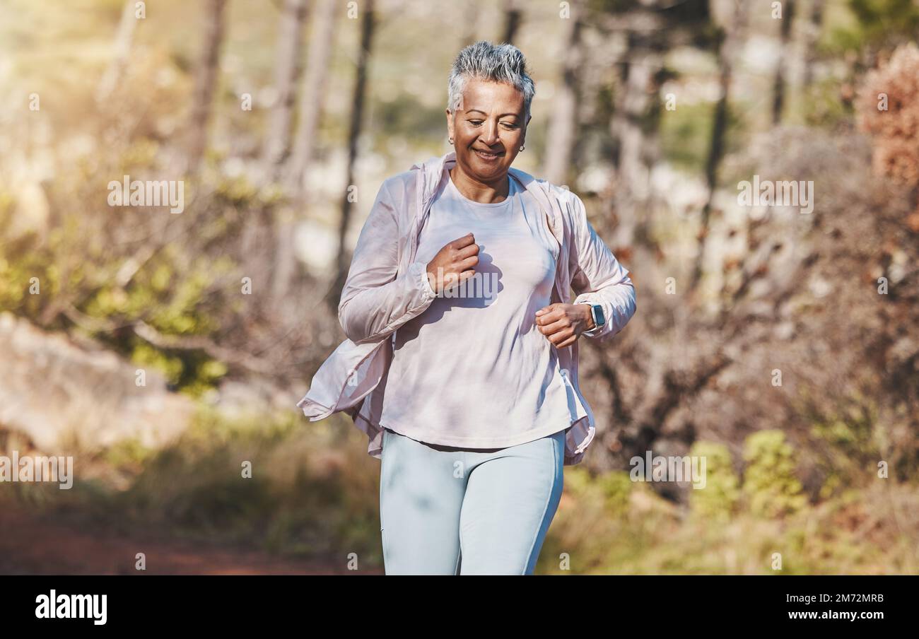 Fitness, runner or old woman running in nature training, exercise or ...