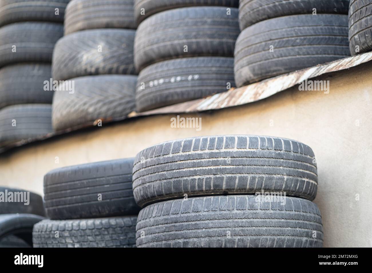 Old used rubber tires stacked with high piles. Hazardous waste requiring recycling and disposal ...