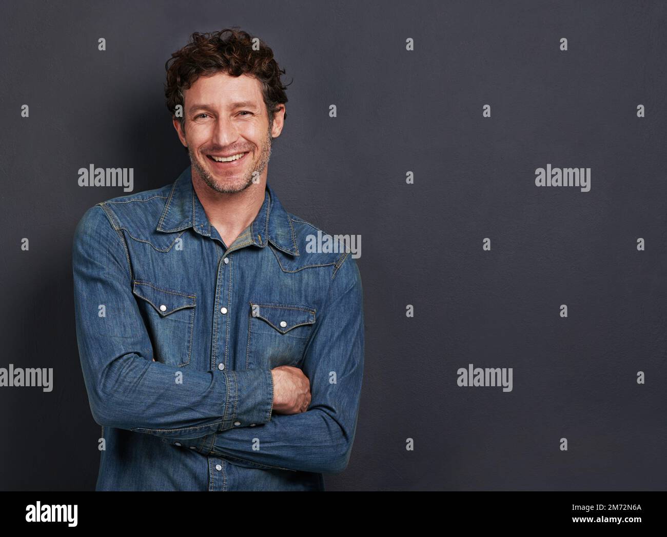 Dashing in denim. Studio portrait of a handsome man standing with his ...