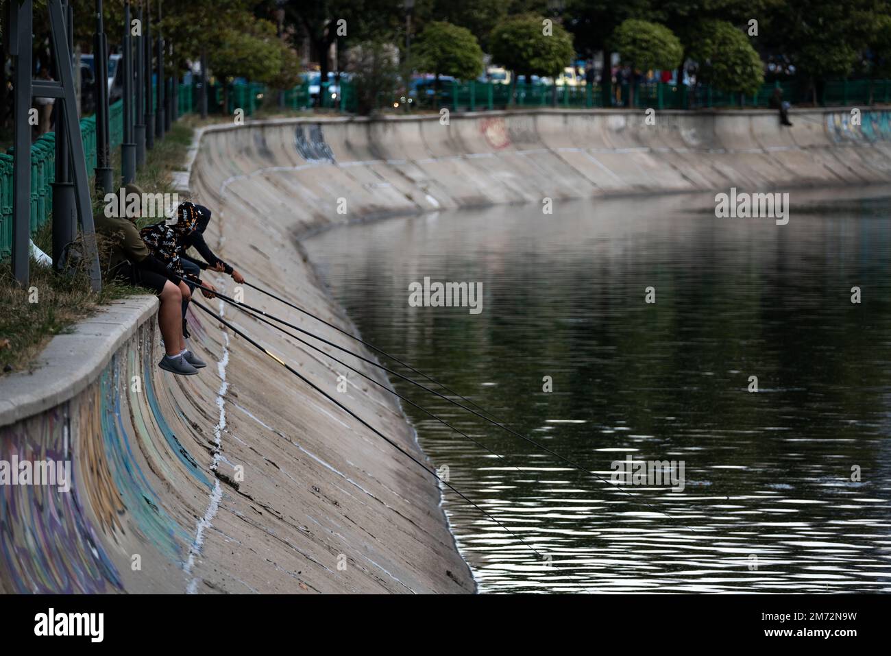 Two young boys fishing on the canal in Bucharest during the daytime ...