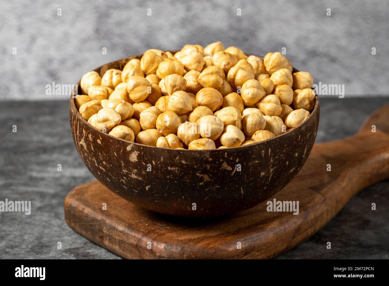 Roasted hazelnut nuts on dark background. Fresh hazelnuts in a coconut ...