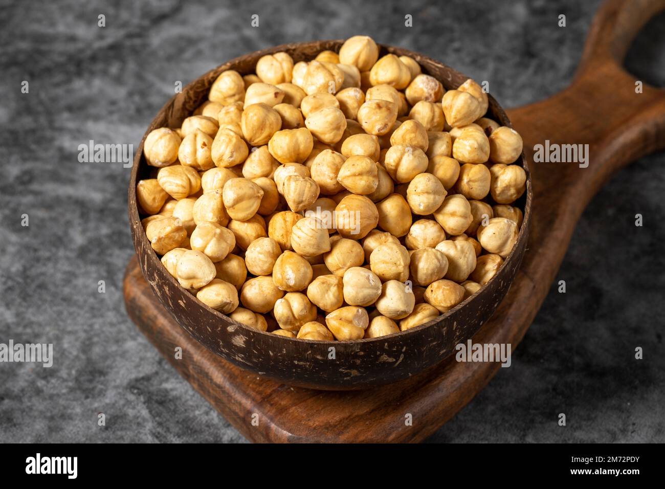 Roasted hazelnut nuts on dark background. Fresh hazelnuts in a coconut ...