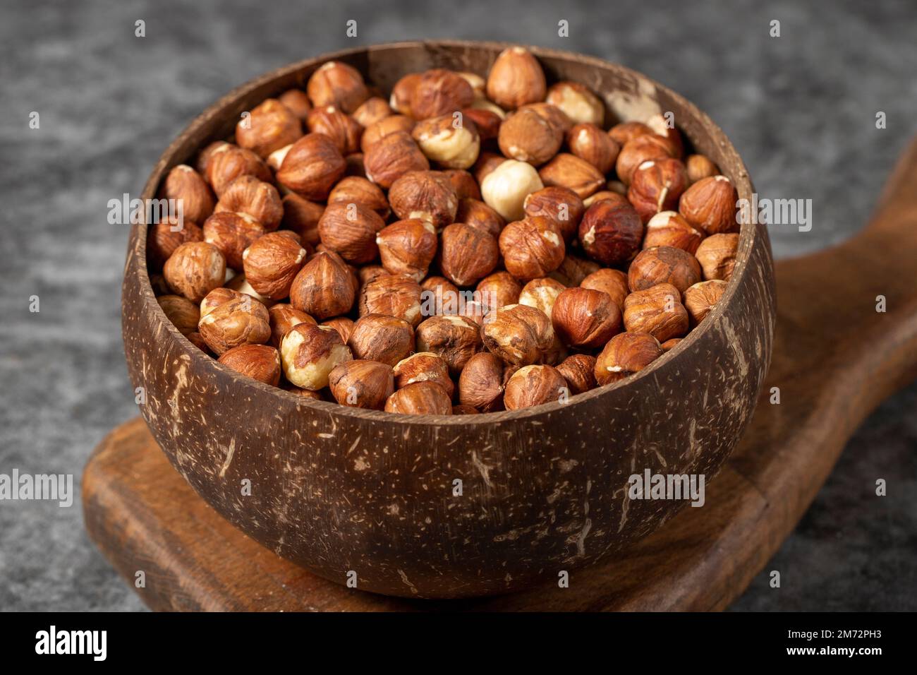 Fresh hazelnut nuts on dark background. Nuts in a coconut bowl. Studio ...