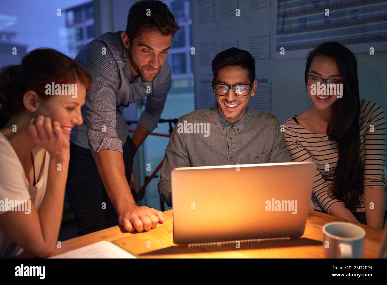 Burning the midnight oil. four colleagues working into the night Stock ...