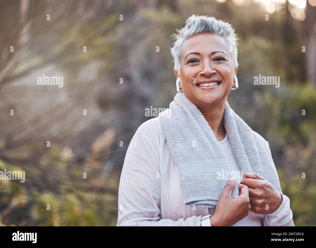 Exercise, music and portrait of a senior woman outdoor with earphones ...