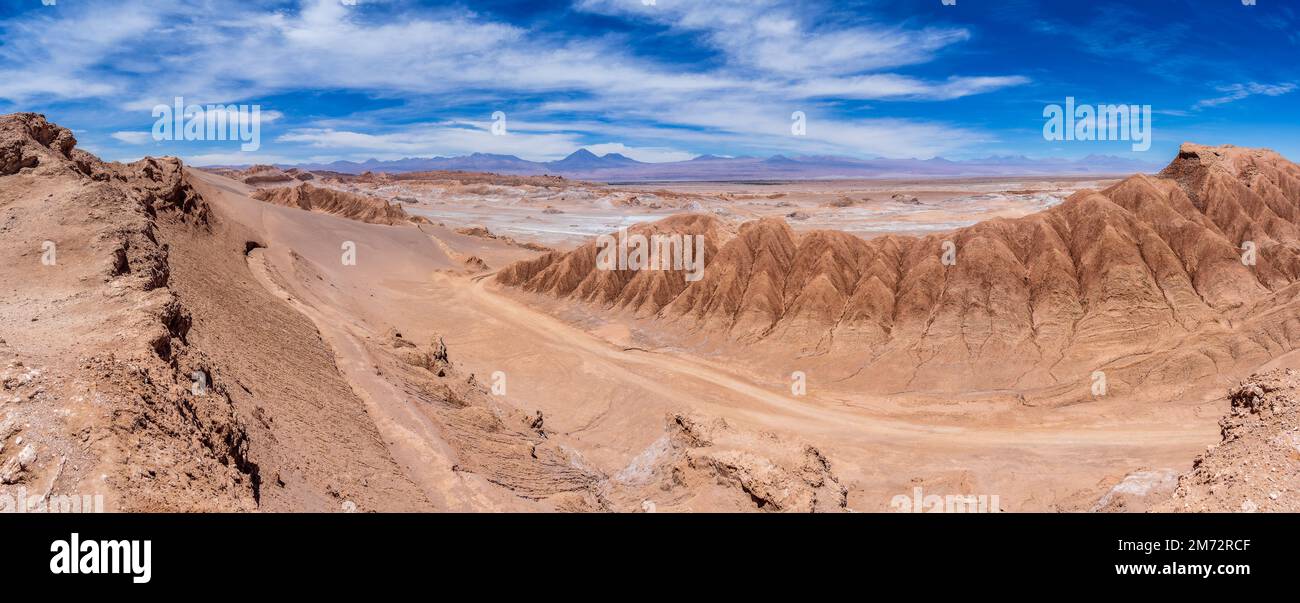 A panoramic view of the Atacama desert in Chile under a cloudy blue sky ...