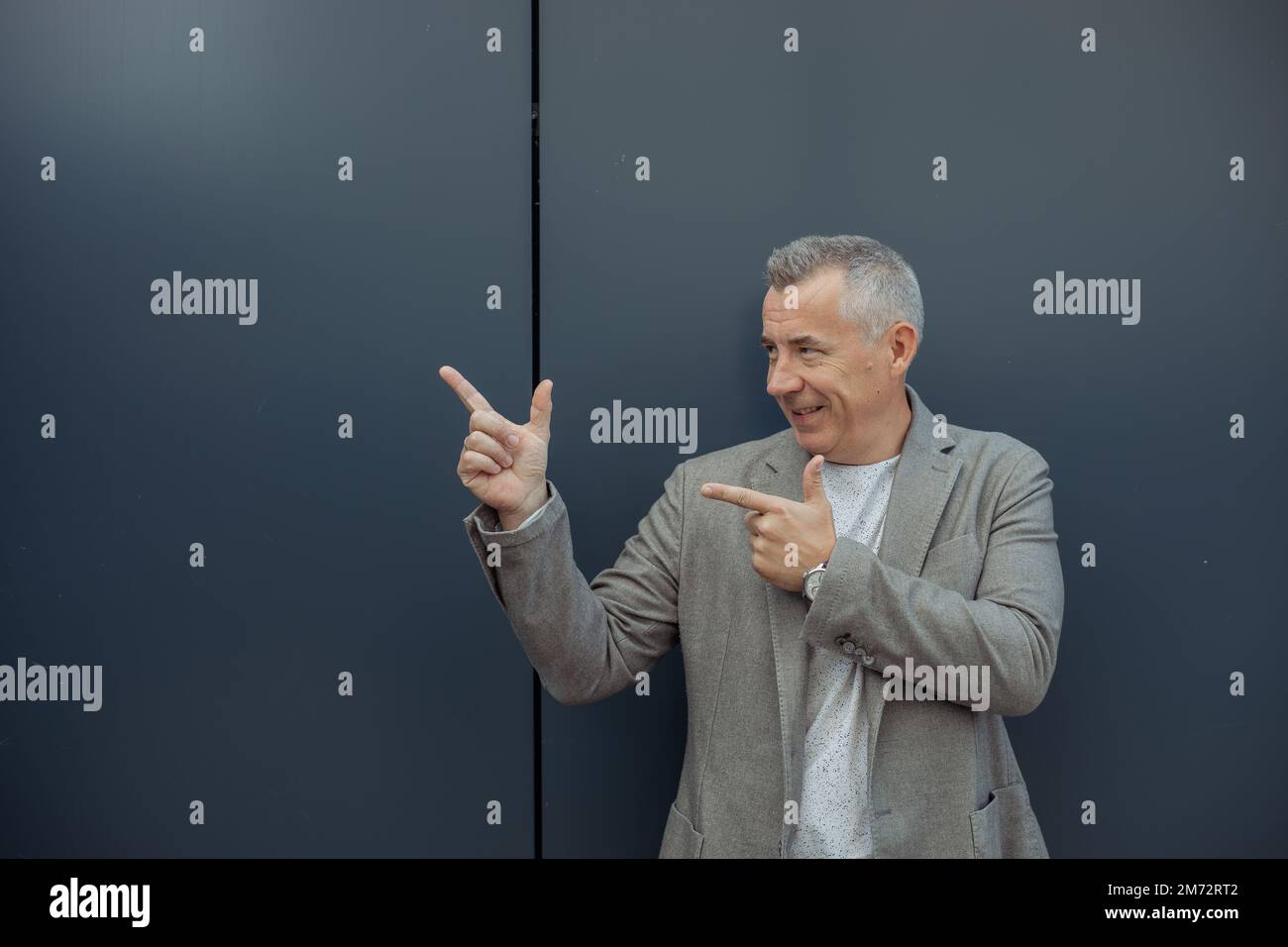 Midsection of smiling, confident grizzled man looking away, showing ...