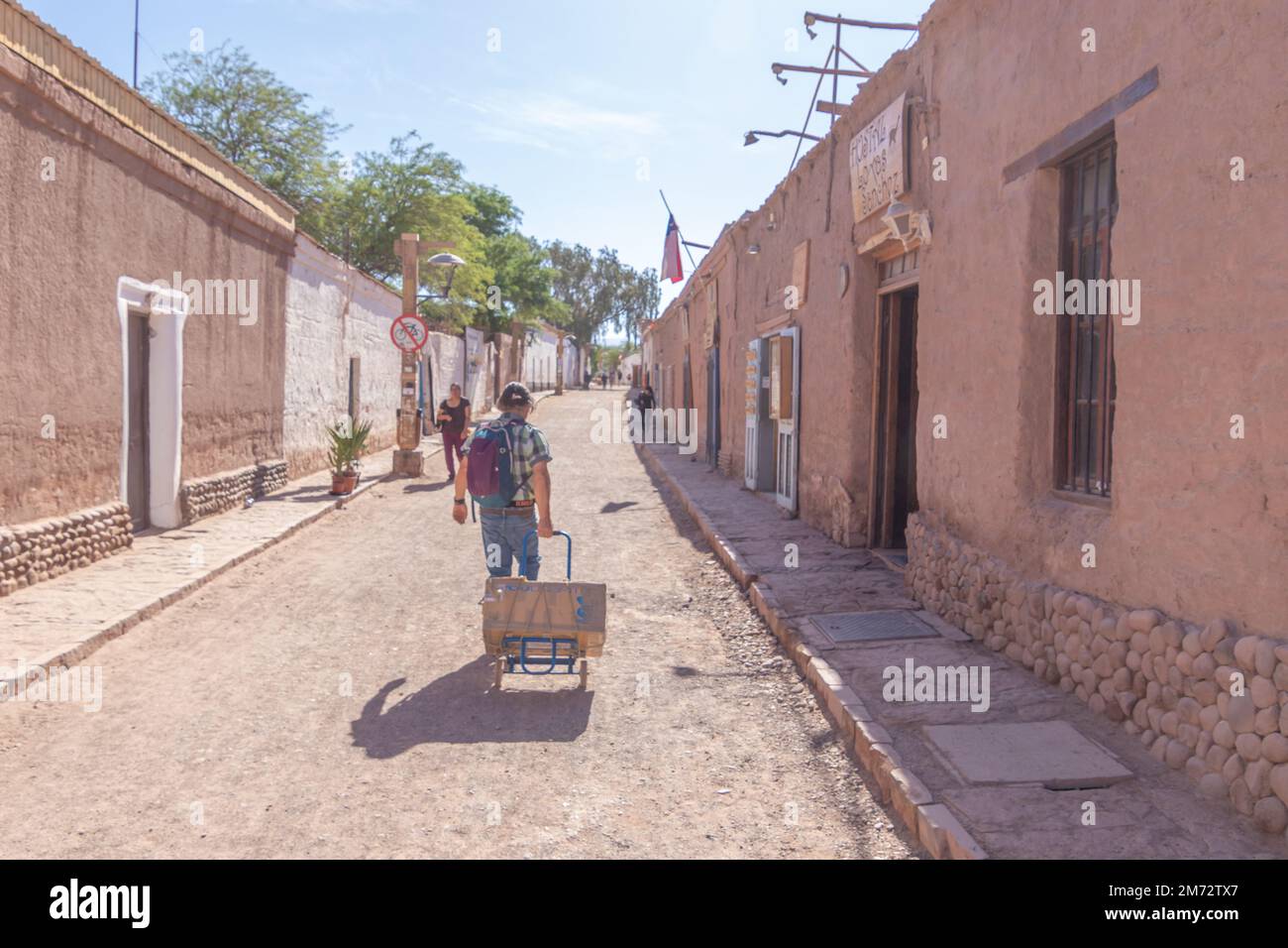 Man walking on the paved main street of San Pedro de Atacama, the only ...