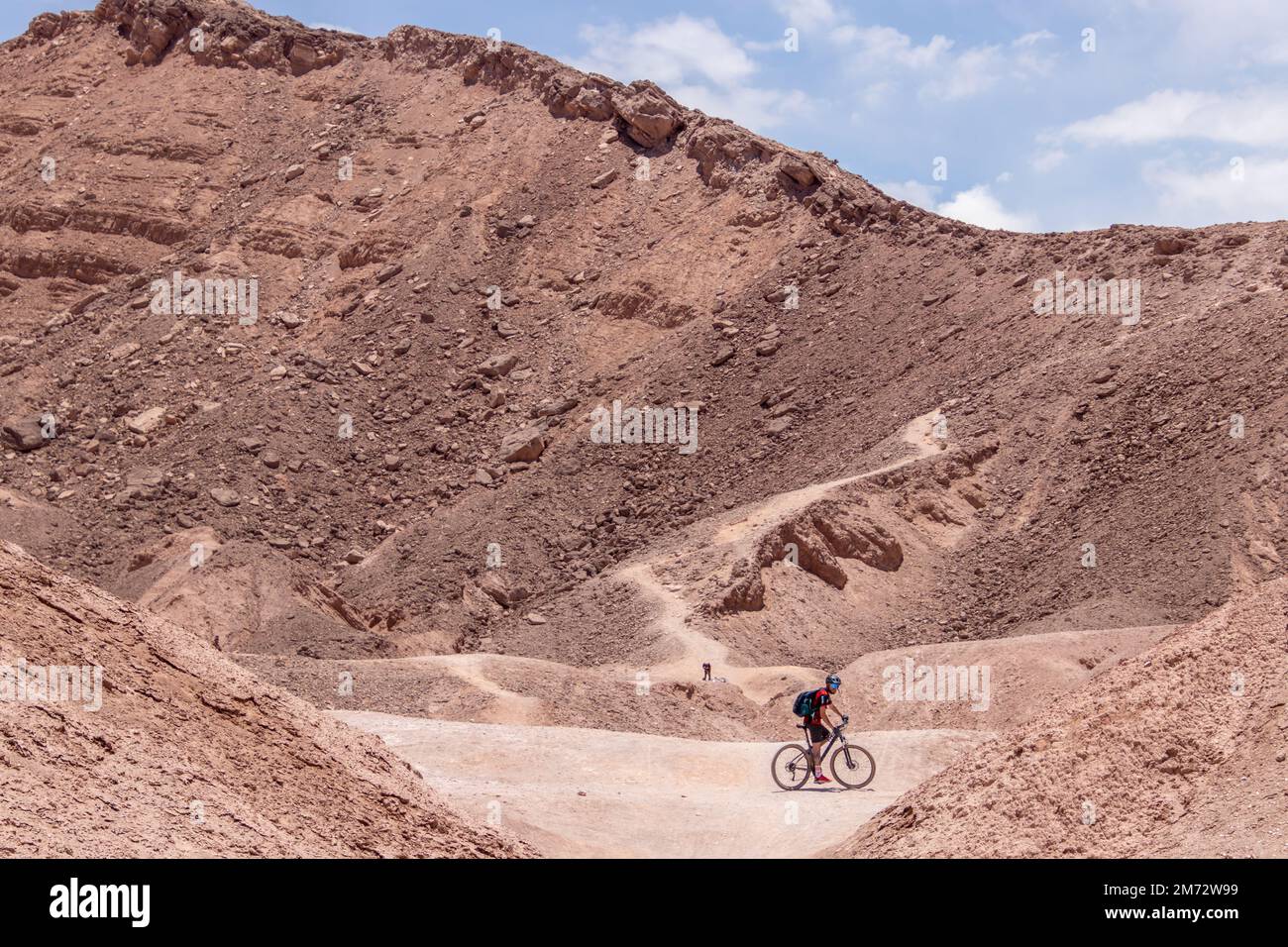 Man cycling in an arid landscape valley near Catarpe, the dryest part ...