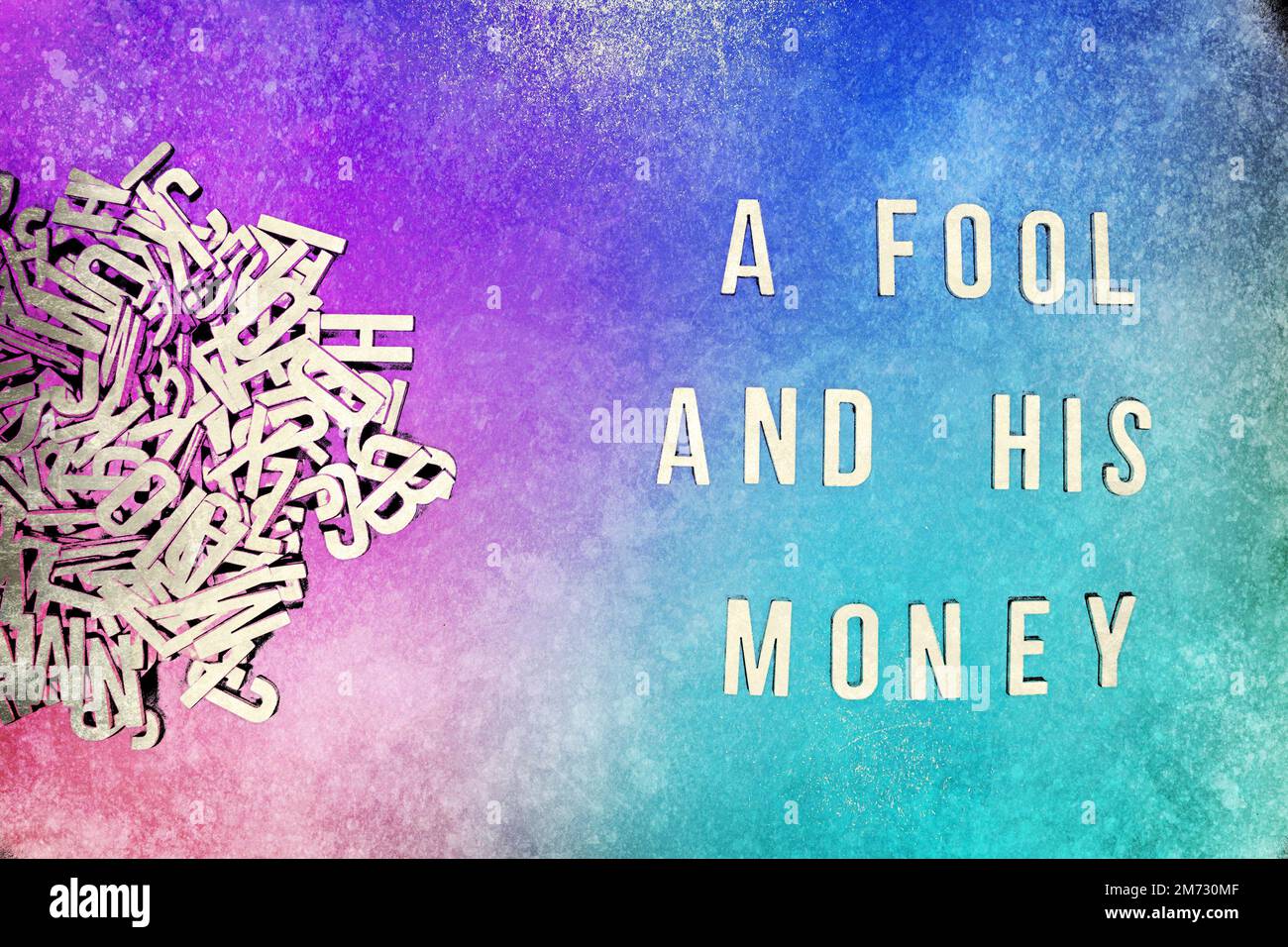 A FOOL AND HIS MONEY in wooden English language capital letters ...