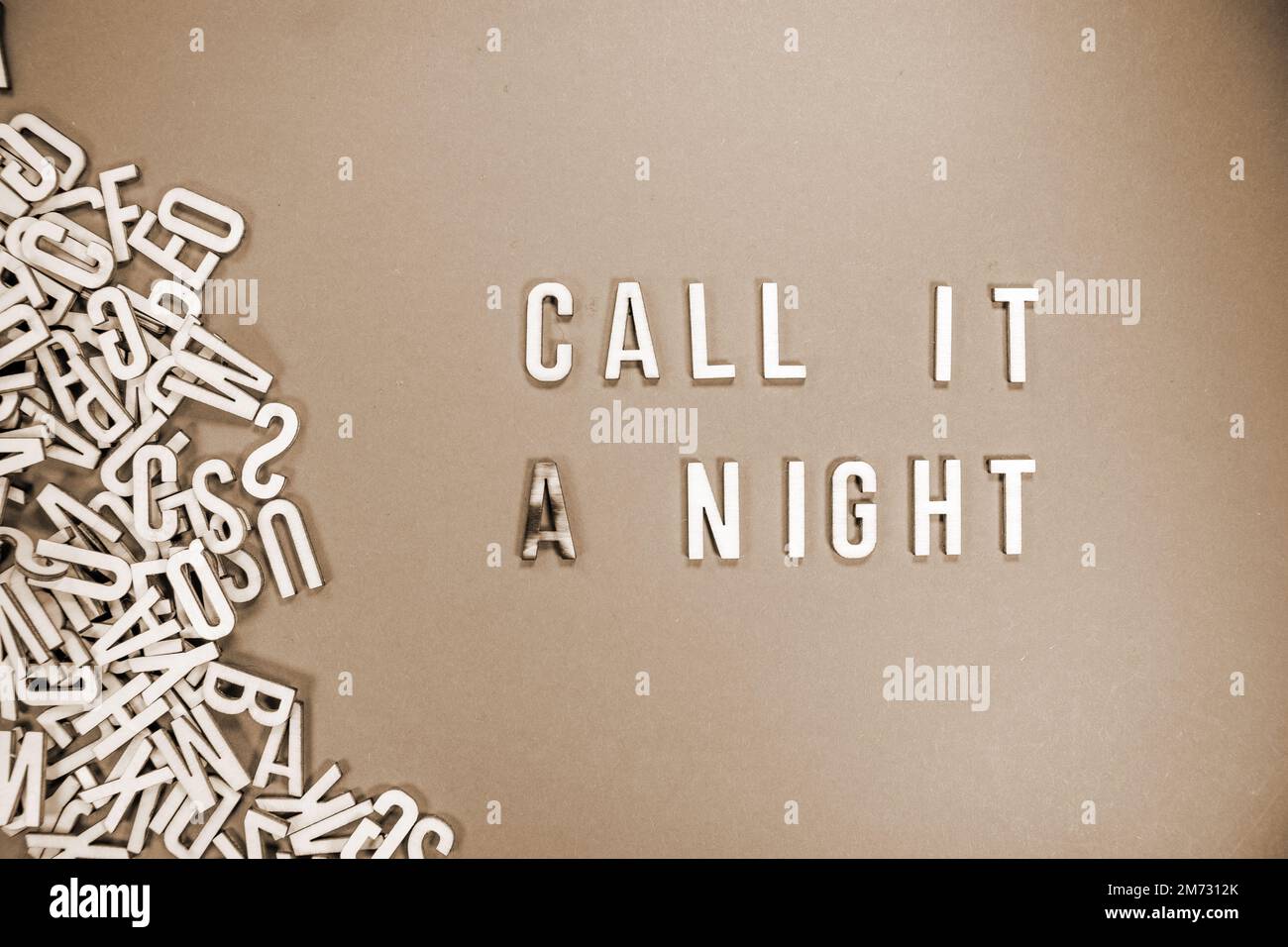 CALL IT A NIGHT in wooden English language capital letters spilling ...